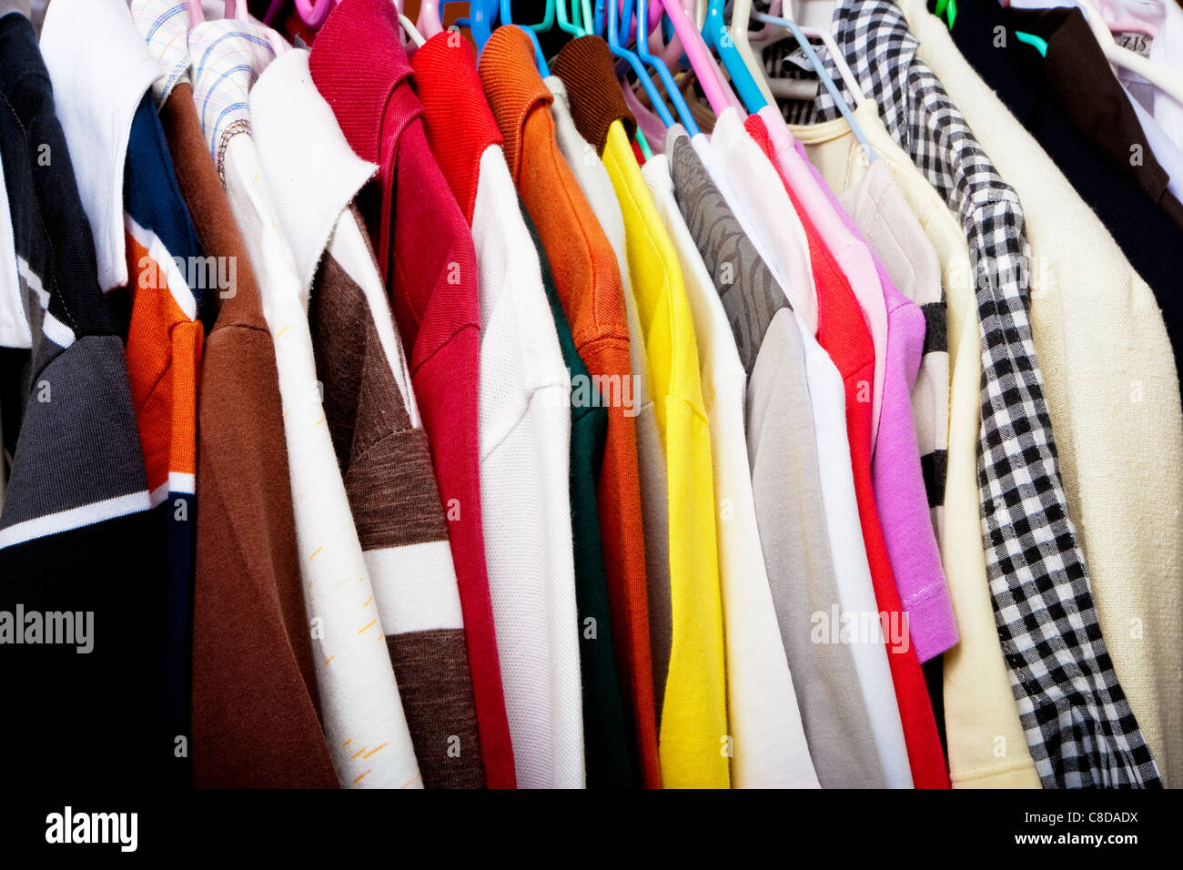 Multi colored shirts on hangers Stock Photo - Alamy