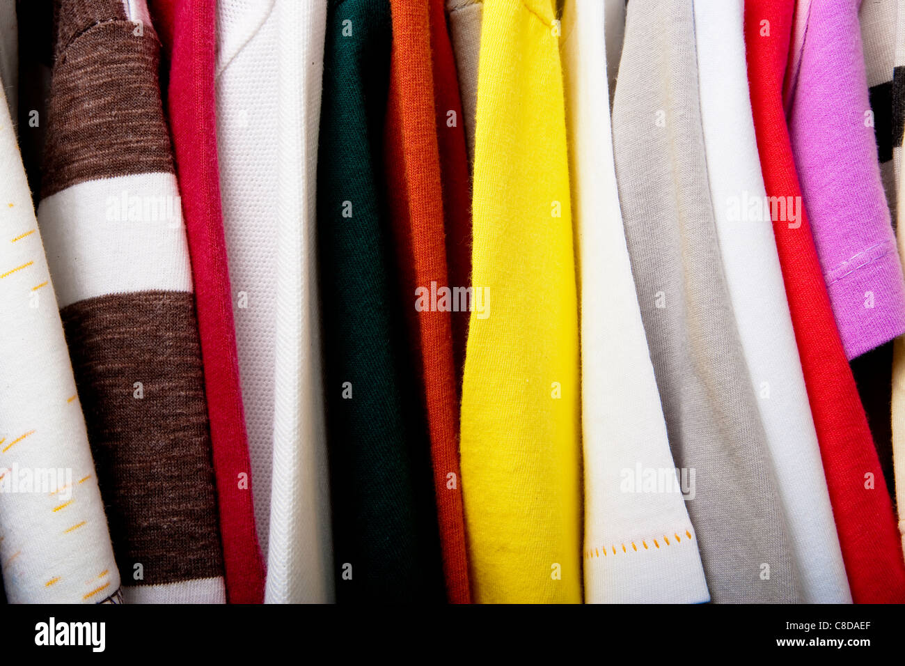 Multi colored shirts on hangers Stock Photo - Alamy