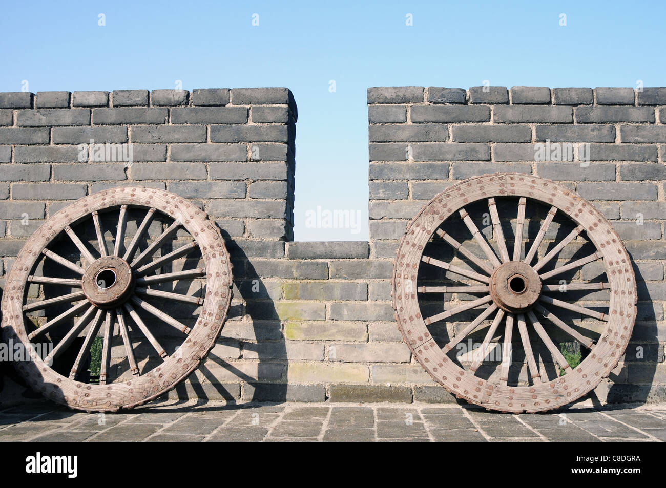 Old carriage wheel against brick wall Stock Photo - Alamy