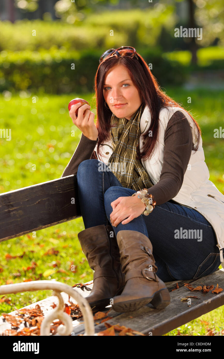 Autumn fashion outfit beautiful woman eat apple sunset nature park ...