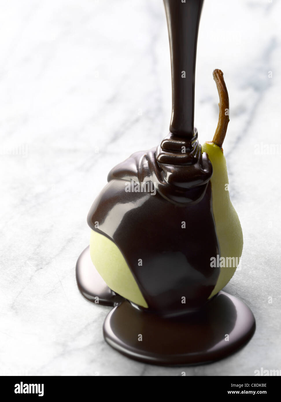 Pouring melted chocolate onto a peeled pear Stock Photo - Alamy