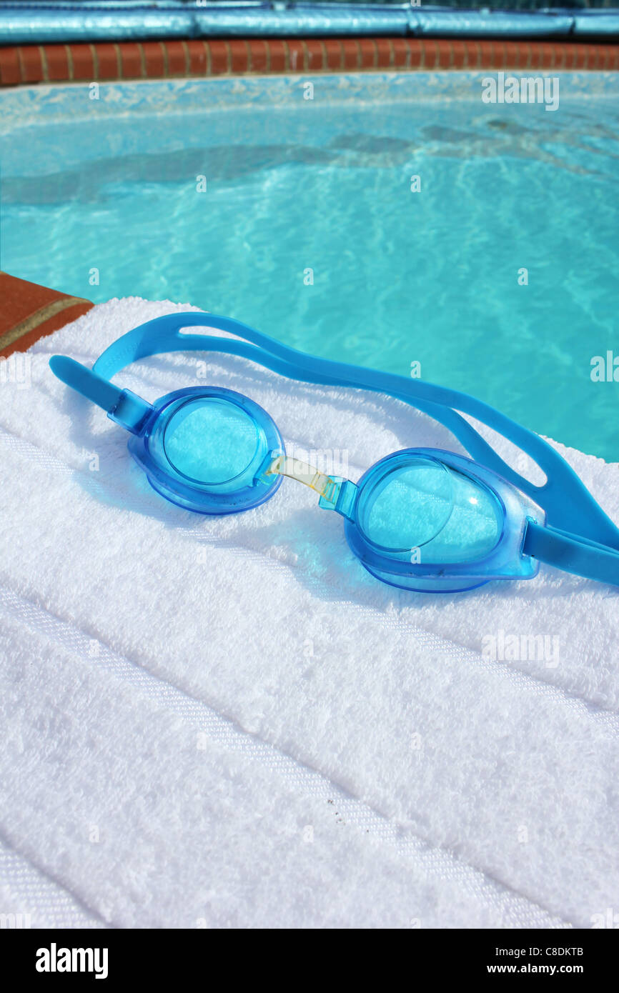 a pair of swimming goggles at the edge of an outdoor pool Stock Photo ...