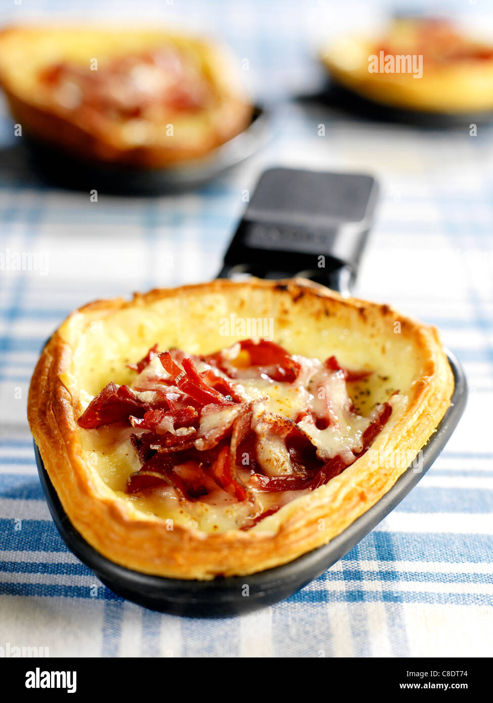 Raclette cheese and grisons meat tart Stock Photo - Alamy