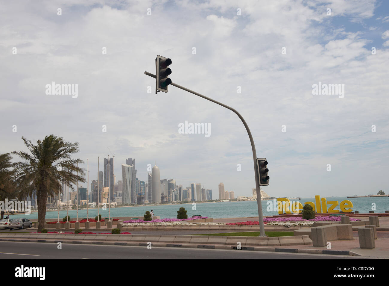 couple sitting on the corniche with doha qatar city skyline in the ...