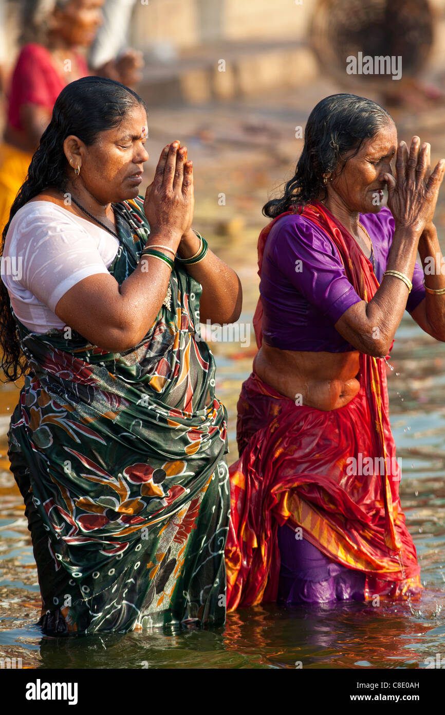 Indian Hindu pilgrims bathing in The Ganges River at Dashashwamedh Ghat ...