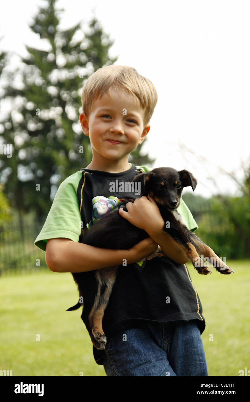 5 year old boy holding puppy dog Stock Photo - Alamy