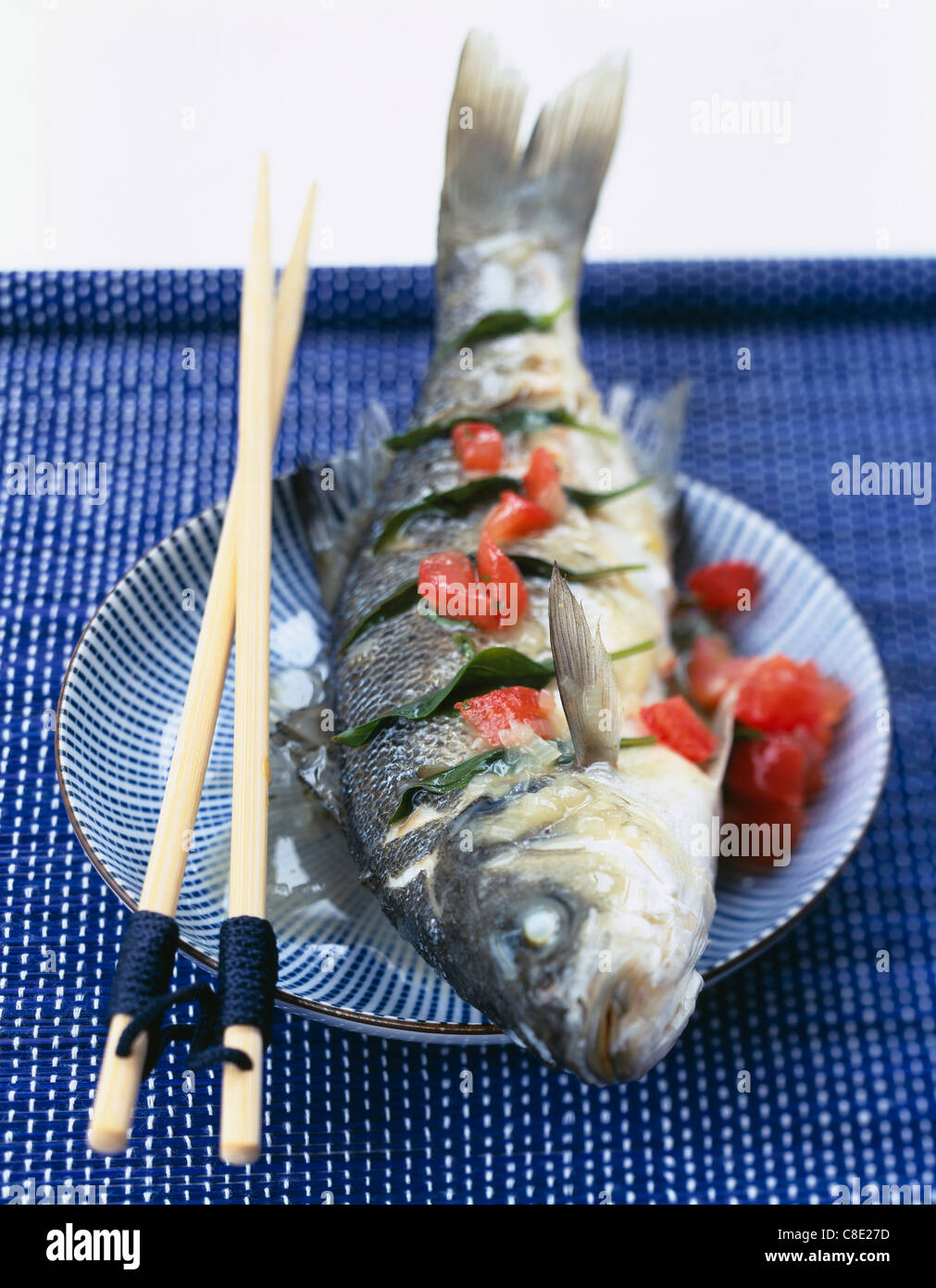 Steam-cooked fish with tomatoes and basil Stock Photo - Alamy