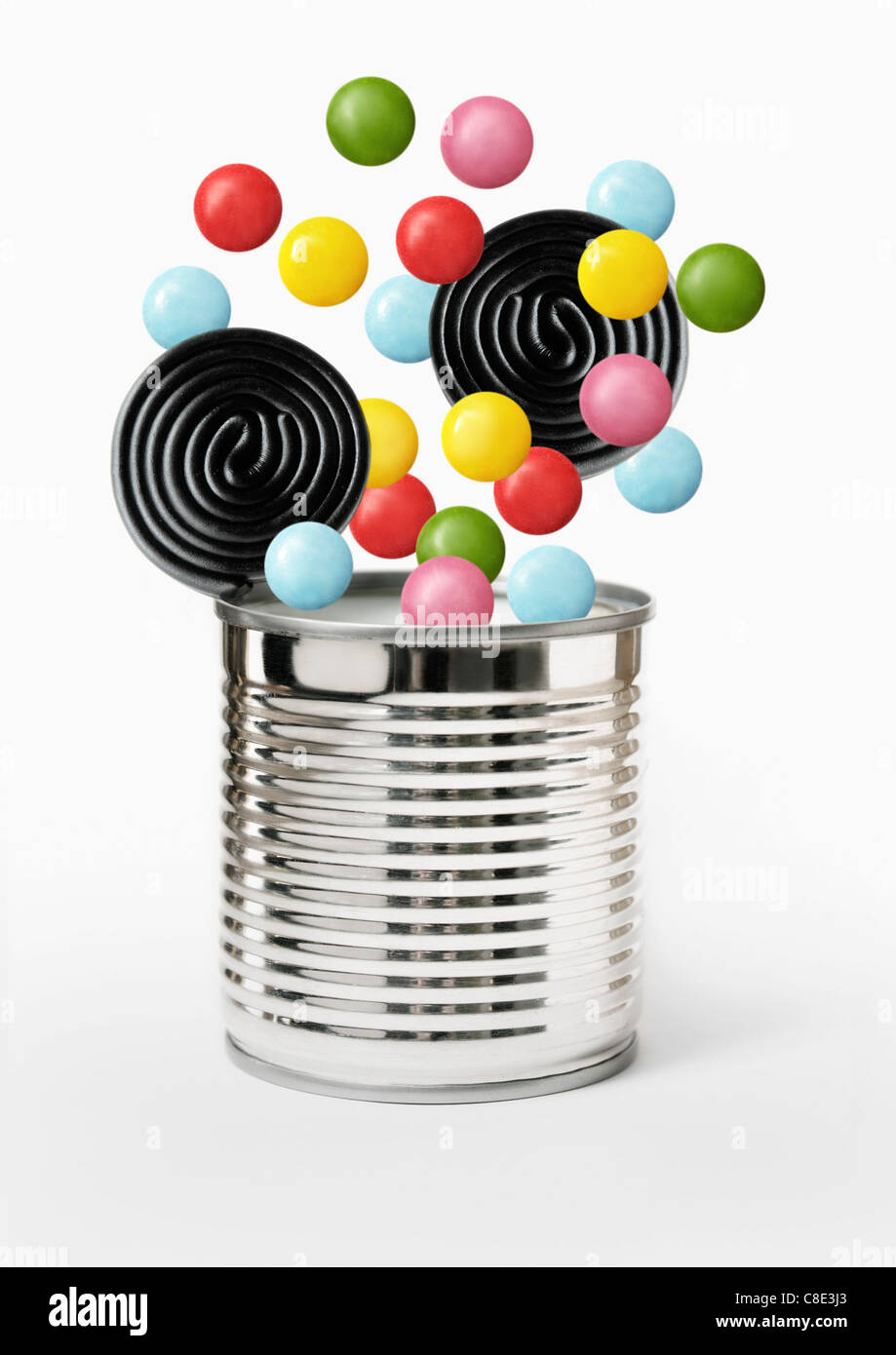 Multicolored candies falling into a can Stock Photo - Alamy