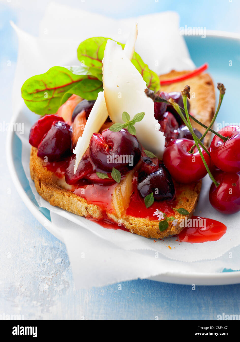 Stewed cherries,cheese and mesclun on toast Stock Photo - Alamy