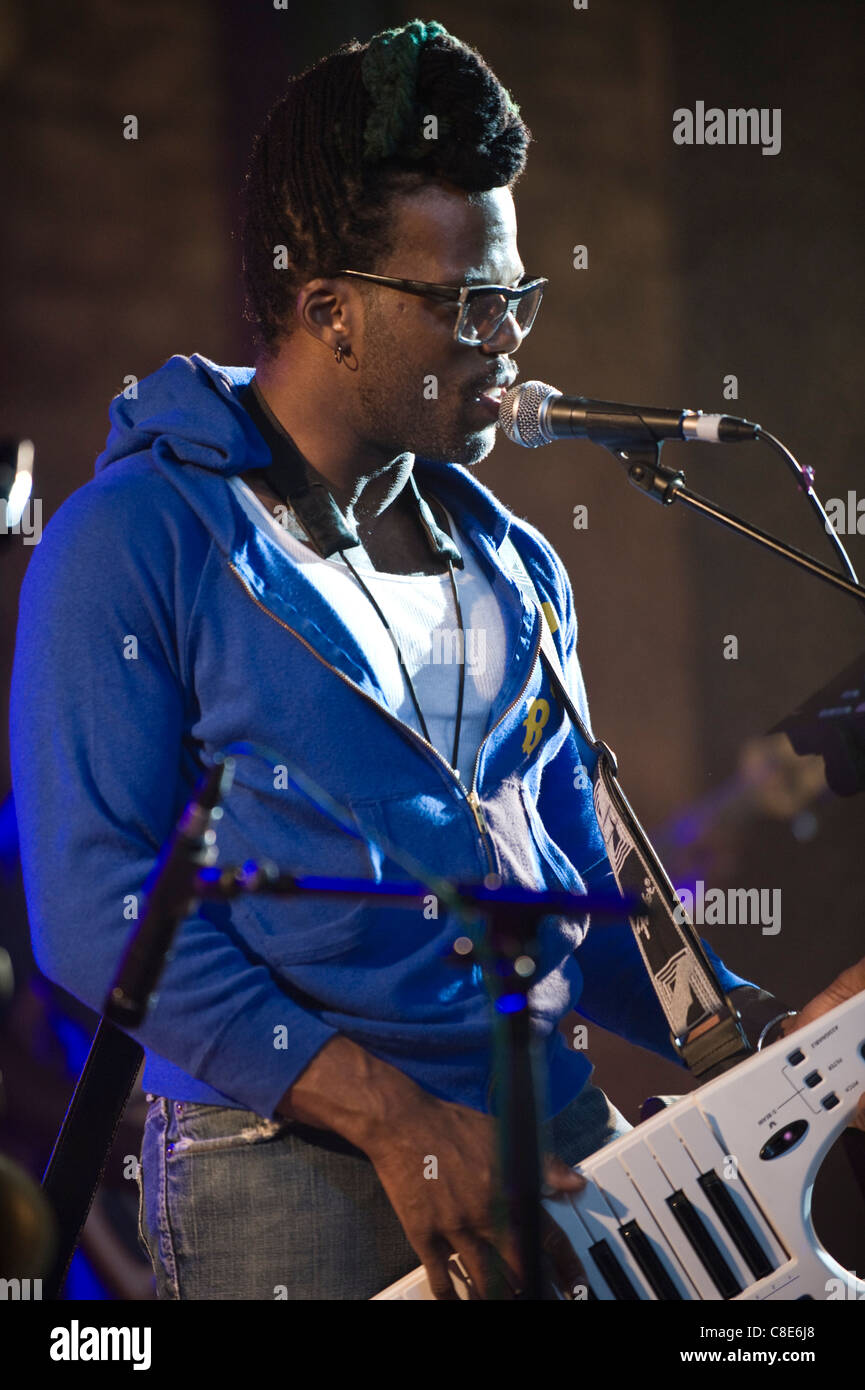 Casey Benjamin playing a Roland AX-Synth shoulder synthesizer on stage ...