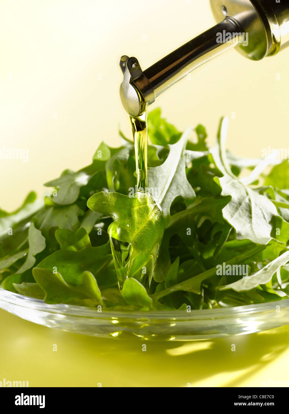 Pouring oil onto a dish of rocket lettuce Stock Photo - Alamy