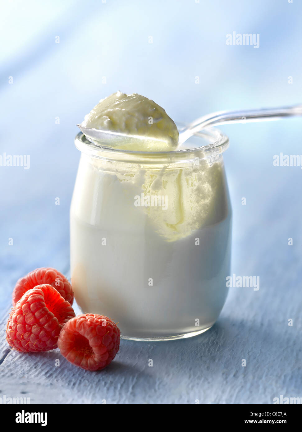 Open yoghurt in a glass pot and raspberries Stock Photo - Alamy