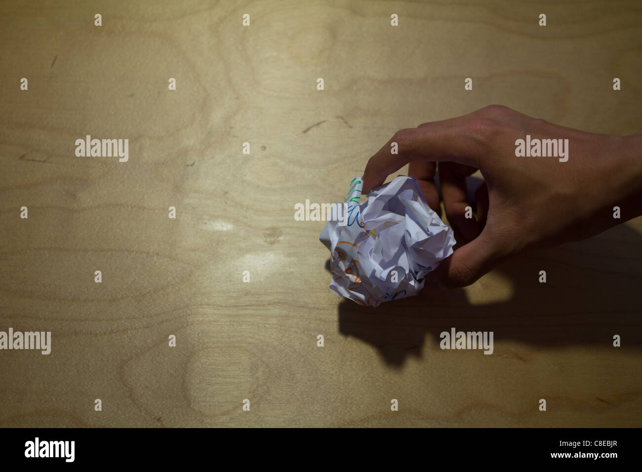 hand holding paper ball on wood table Stock Photo - Alamy