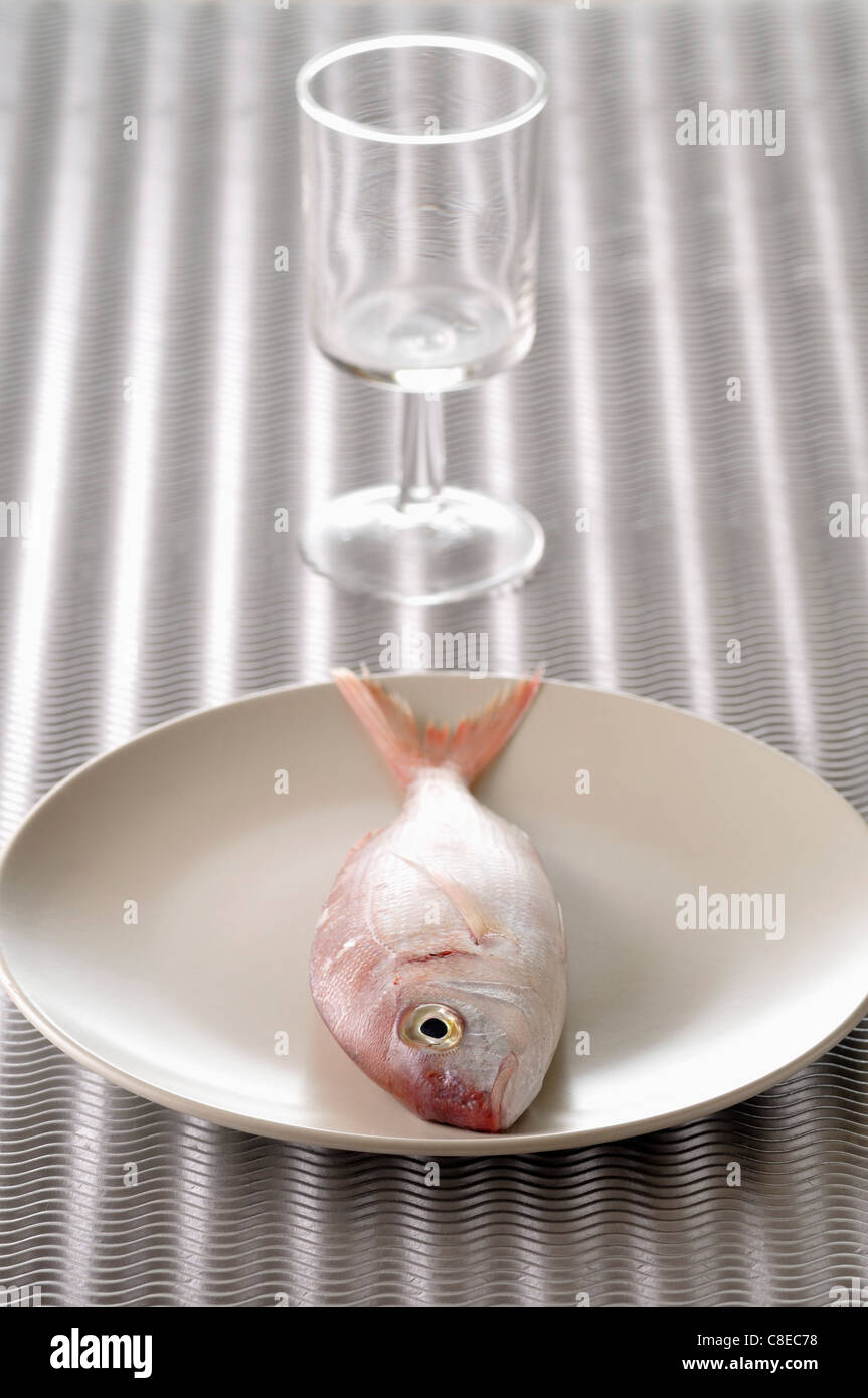 Whole raw fish on a plate Stock Photo - Alamy
