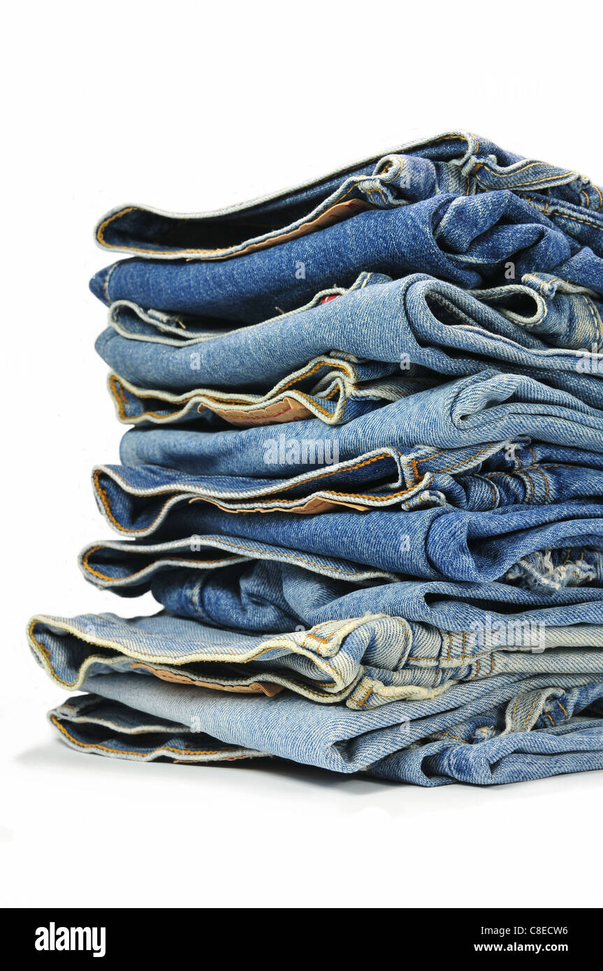Pile of blue denim jeans isolated on white background Stock Photo - Alamy