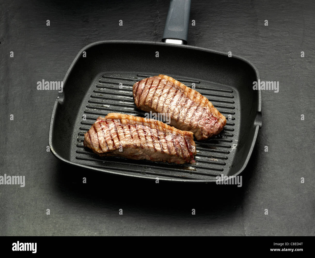 Cooking steaks in a grill-pan Stock Photo - Alamy
