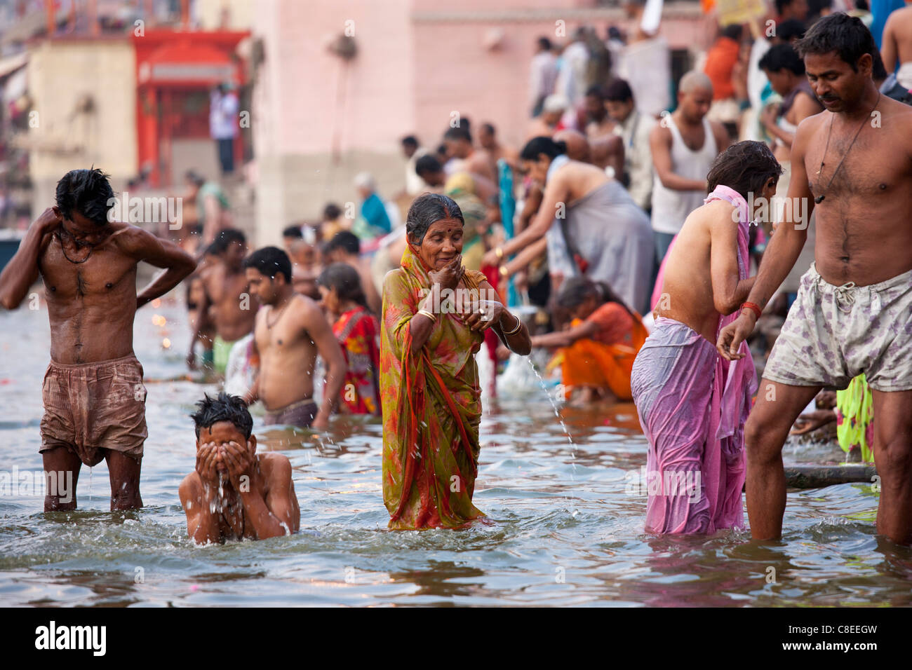 Indian Hindu pilgrims bathing in The Ganges River at Dashashwamedh Ghat ...