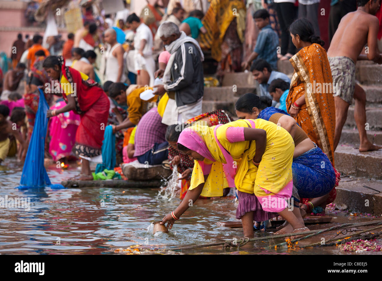 Indian Hindu pilgrims bathing in The Ganges River at Dashashwamedh Ghat ...