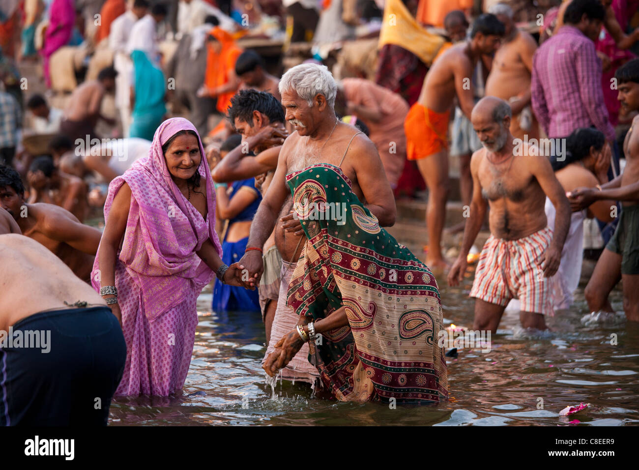 Indian Hindu pilgrims bathing in The Ganges River at Dashashwamedh Ghat ...
