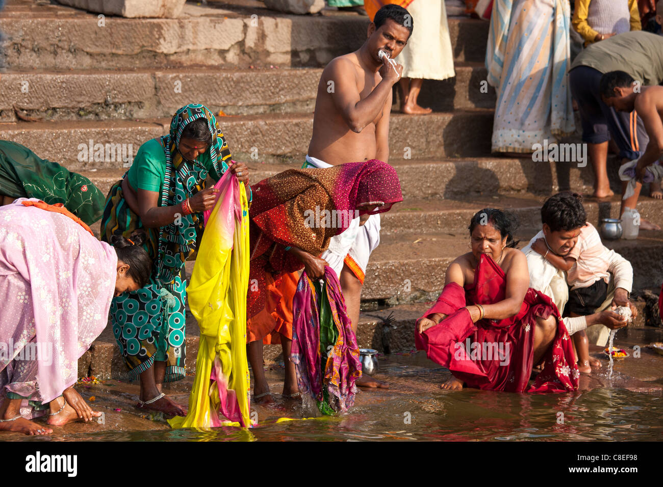 Indian Hindu pilgrims bathing in The Ganges River at Dashashwamedh Ghat ...
