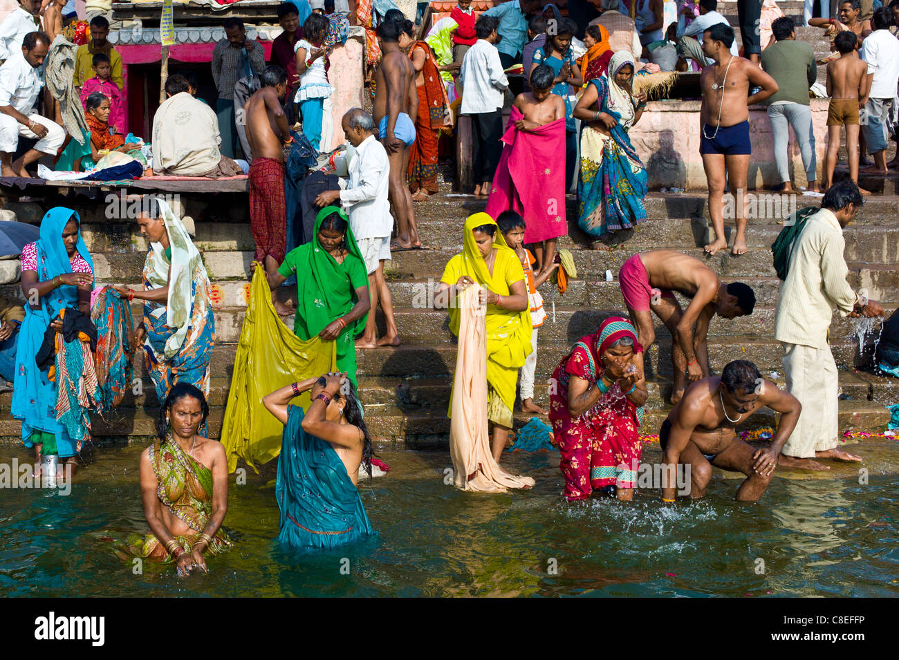 Indian Hindu pilgrims bathing in The Ganges River at Dashashwamedh Ghat ...
