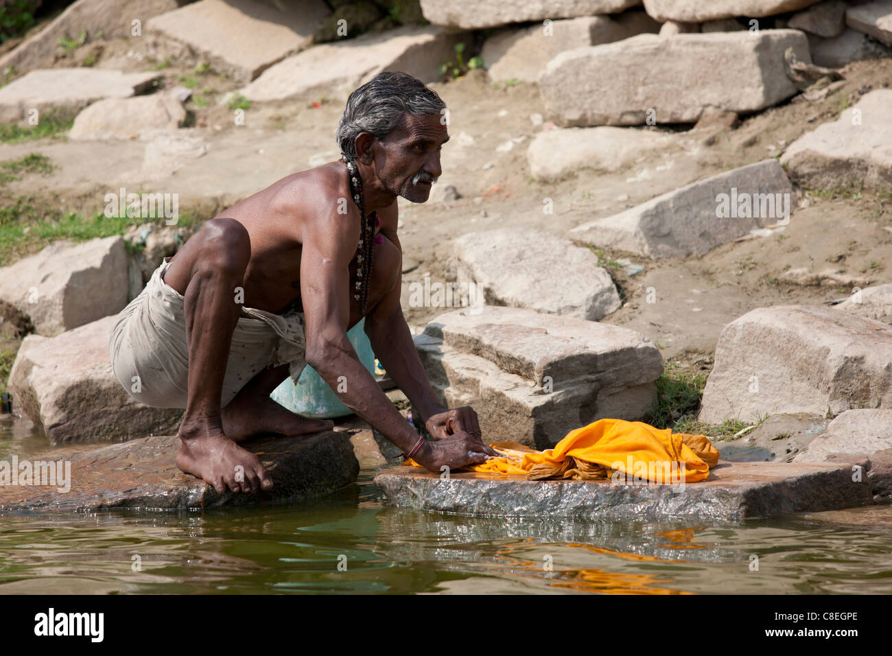 Indian washing clothing in River Ganges using traditional method at ...