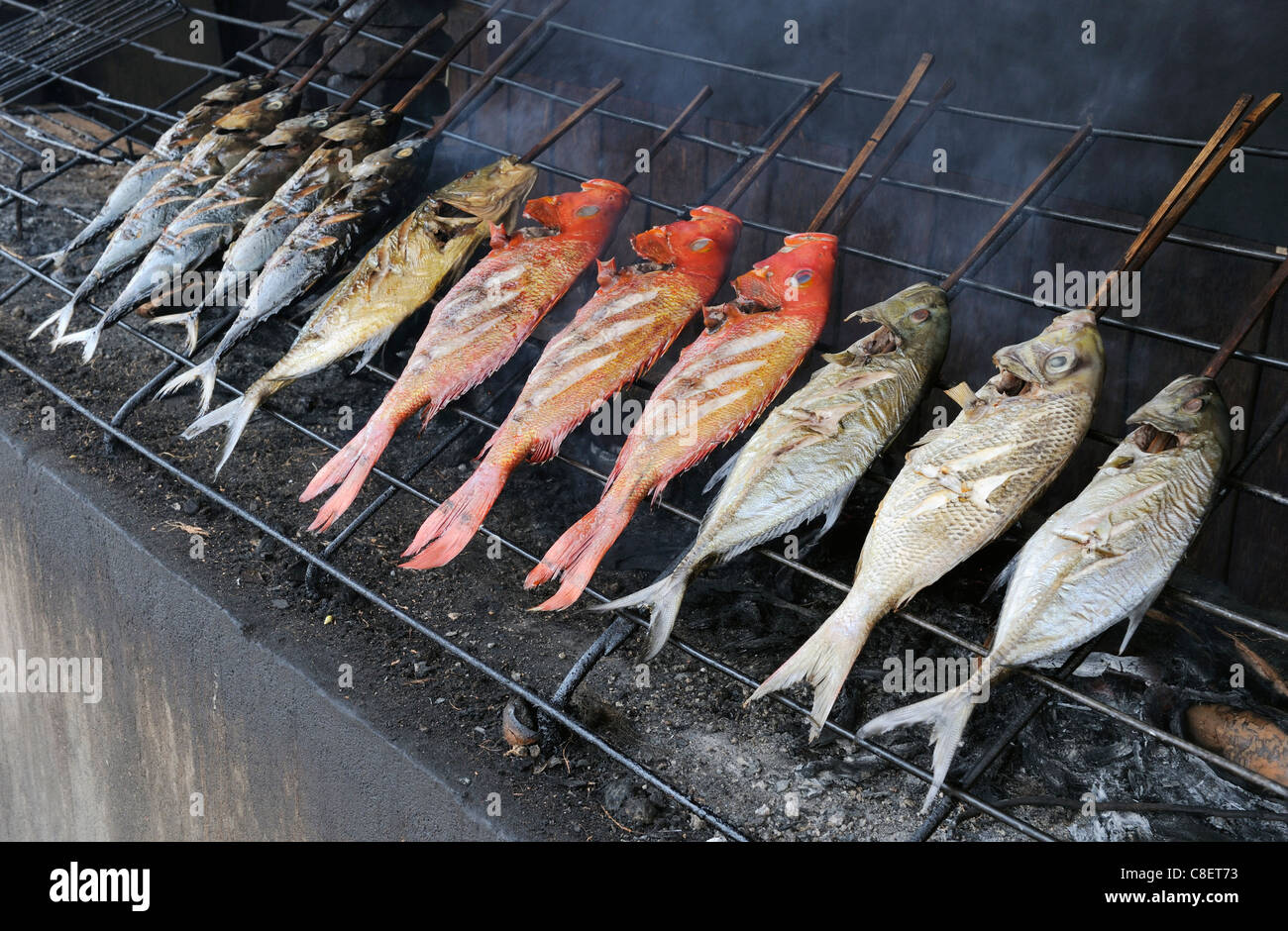Colored reef fish on an asian barbecue Stock Photo - Alamy