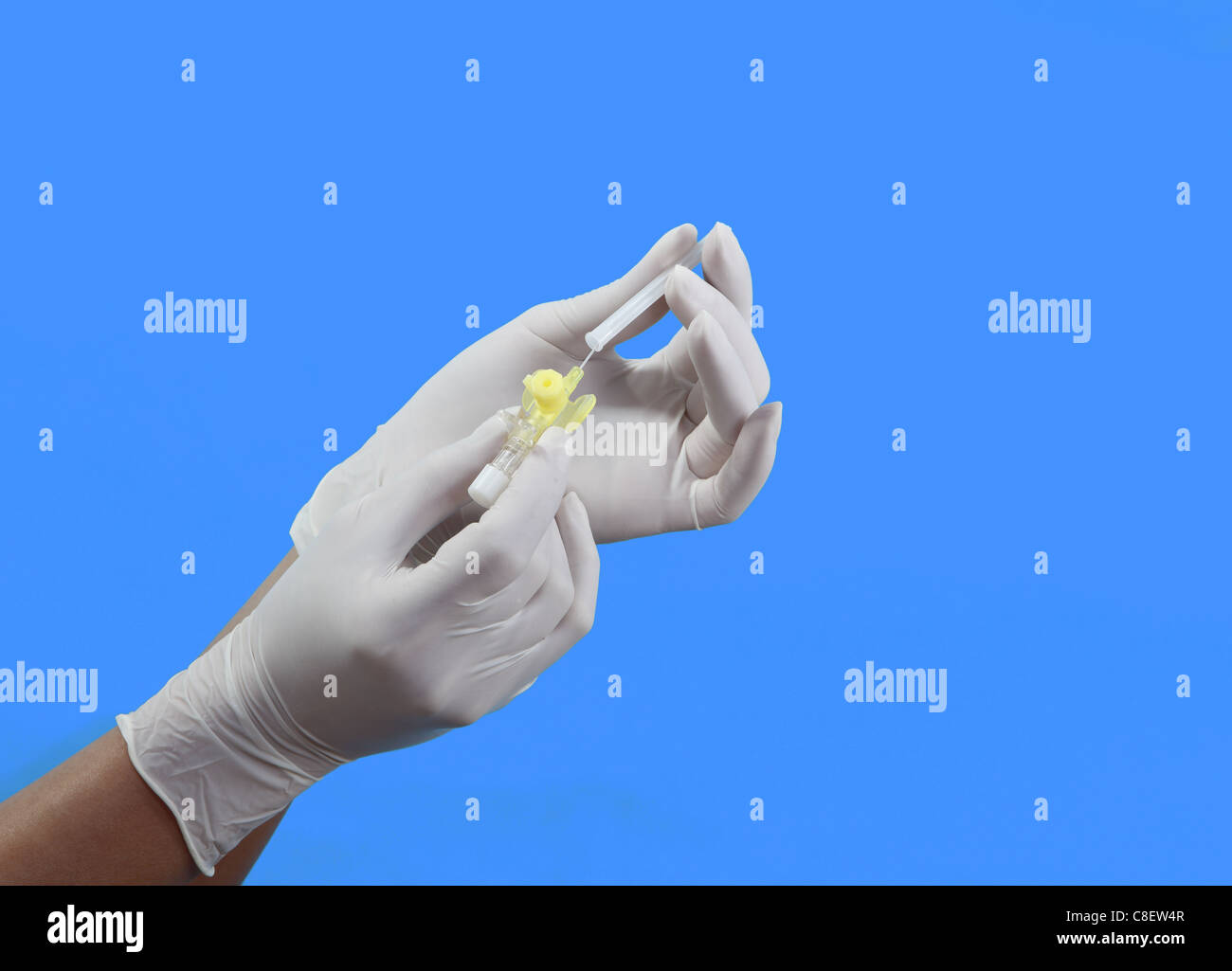 Hand in surgical gloves preparing a small intravenous puncture needle ...