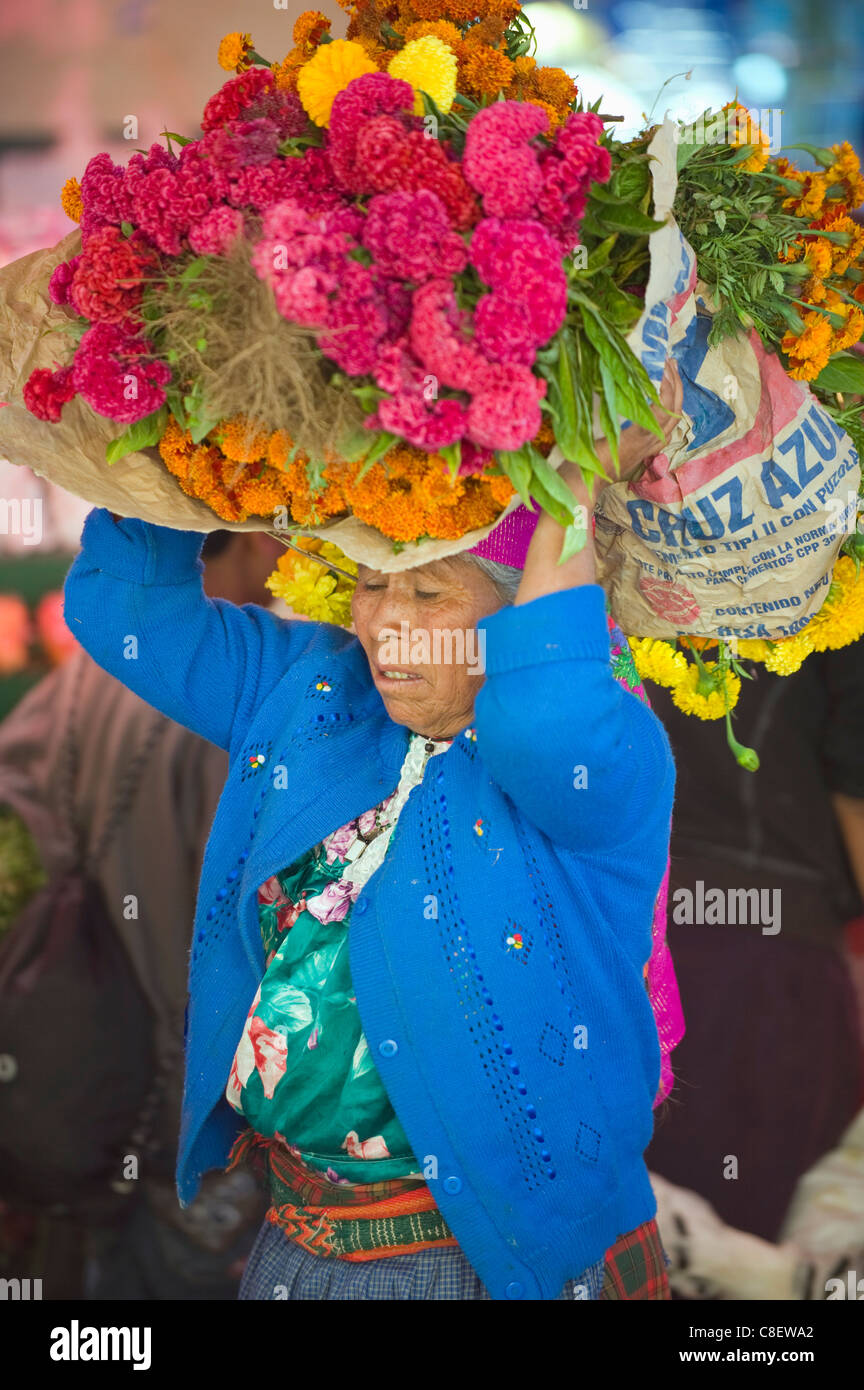 Woman carrying flowers at Tlacolula Sunday market, Oaxaca state, Mexico ...