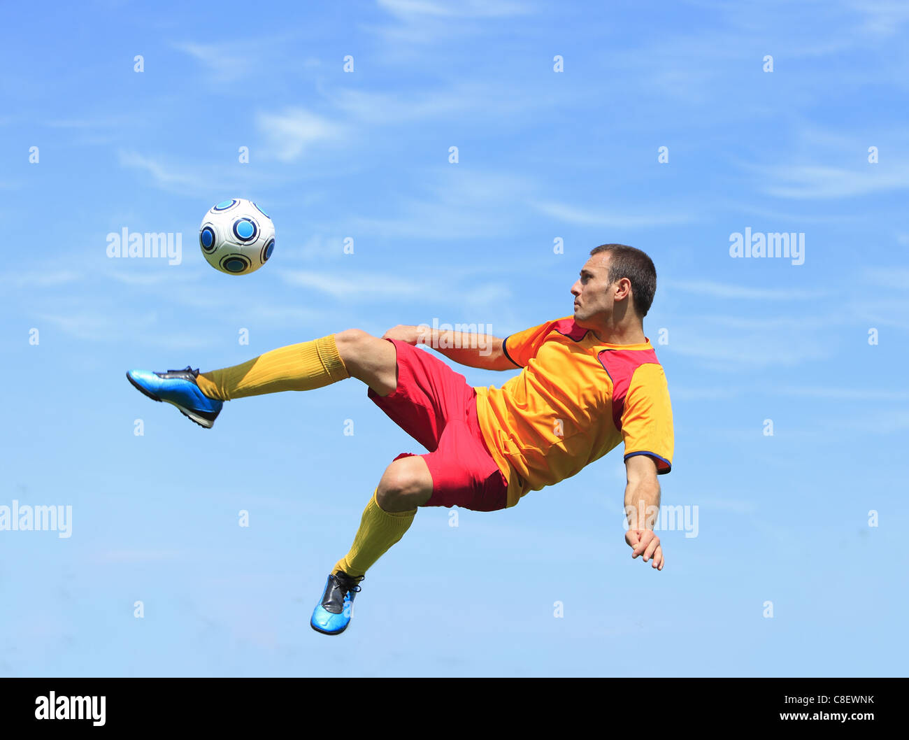 A soccer player kicking the ball in an acrobatic position Stock Photo ...