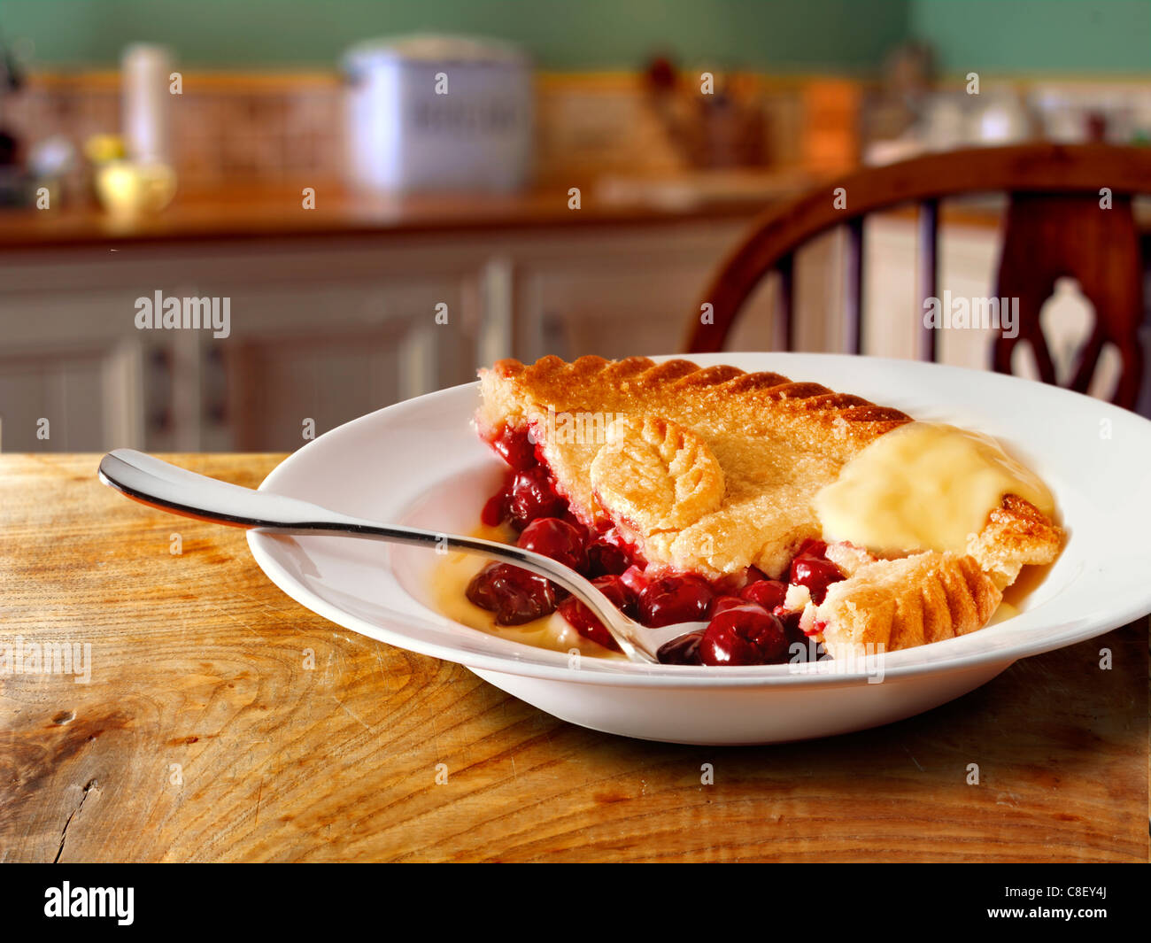 Traditional British cherry pie and custard pudding served hot in a bowl ...