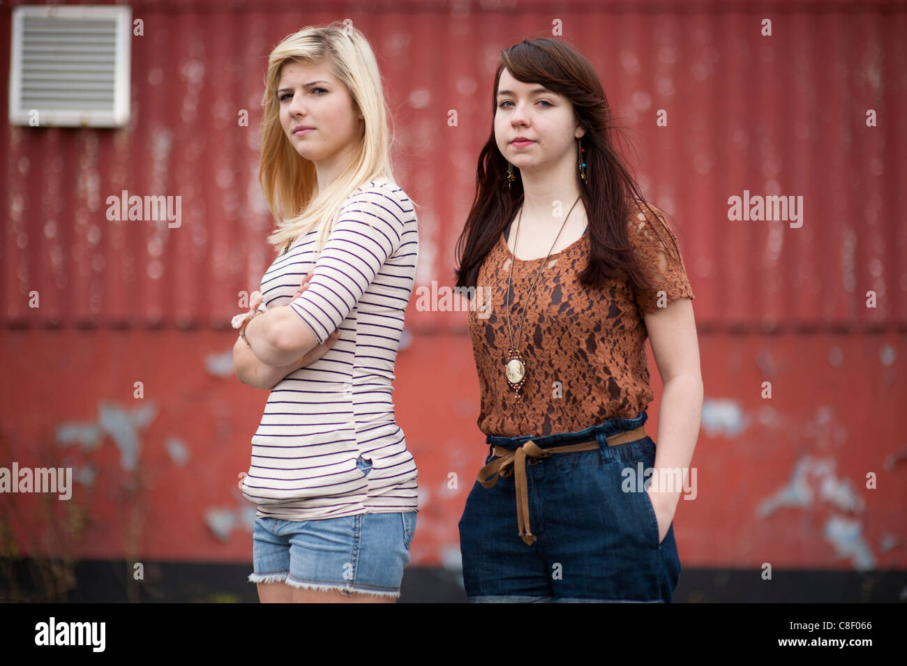 Two 16 17 year old teenage girls, UK, standing outside, with attitude ...