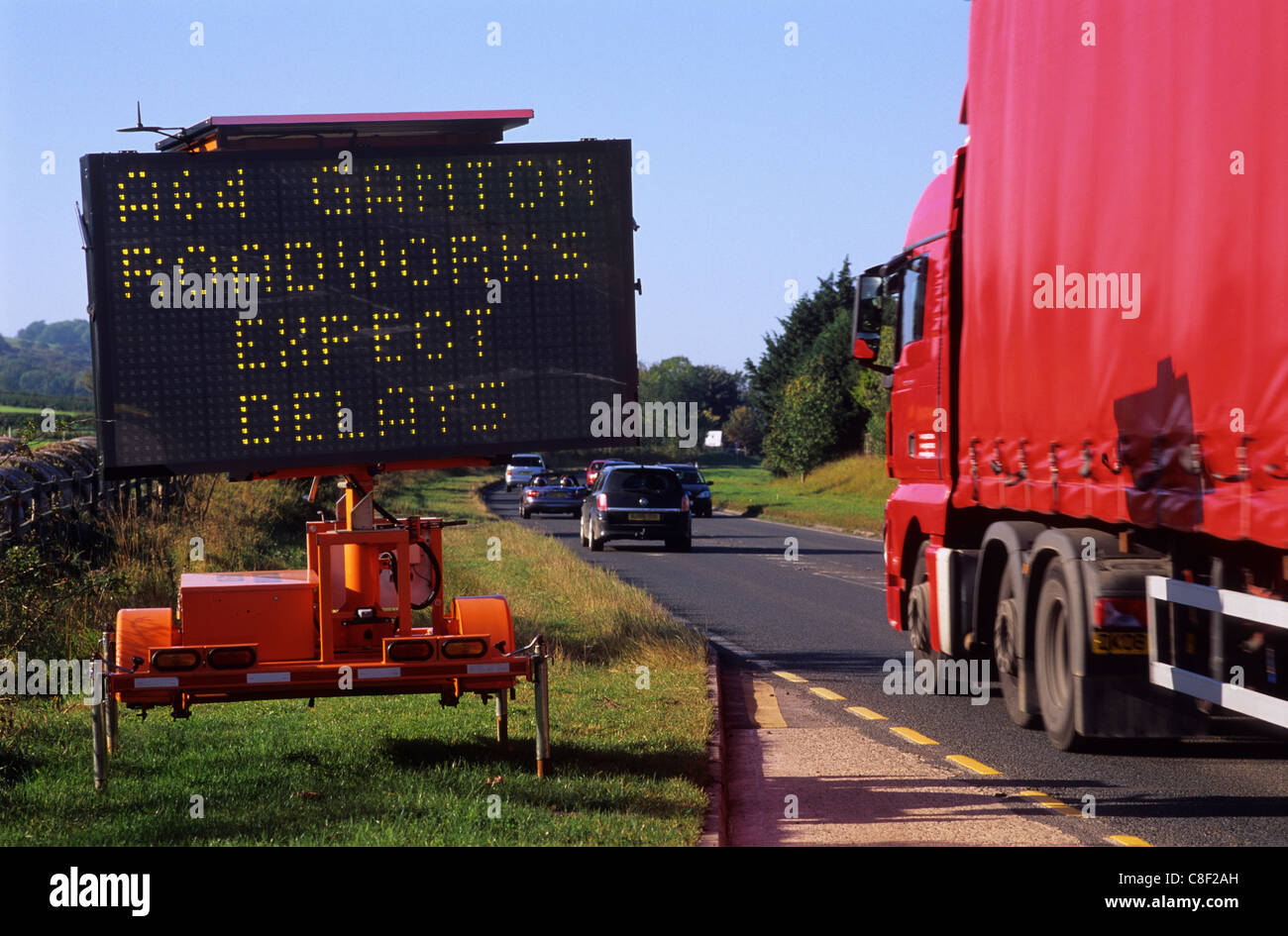 roadside electronic warning sign of roadworks and delays on road ahead ...