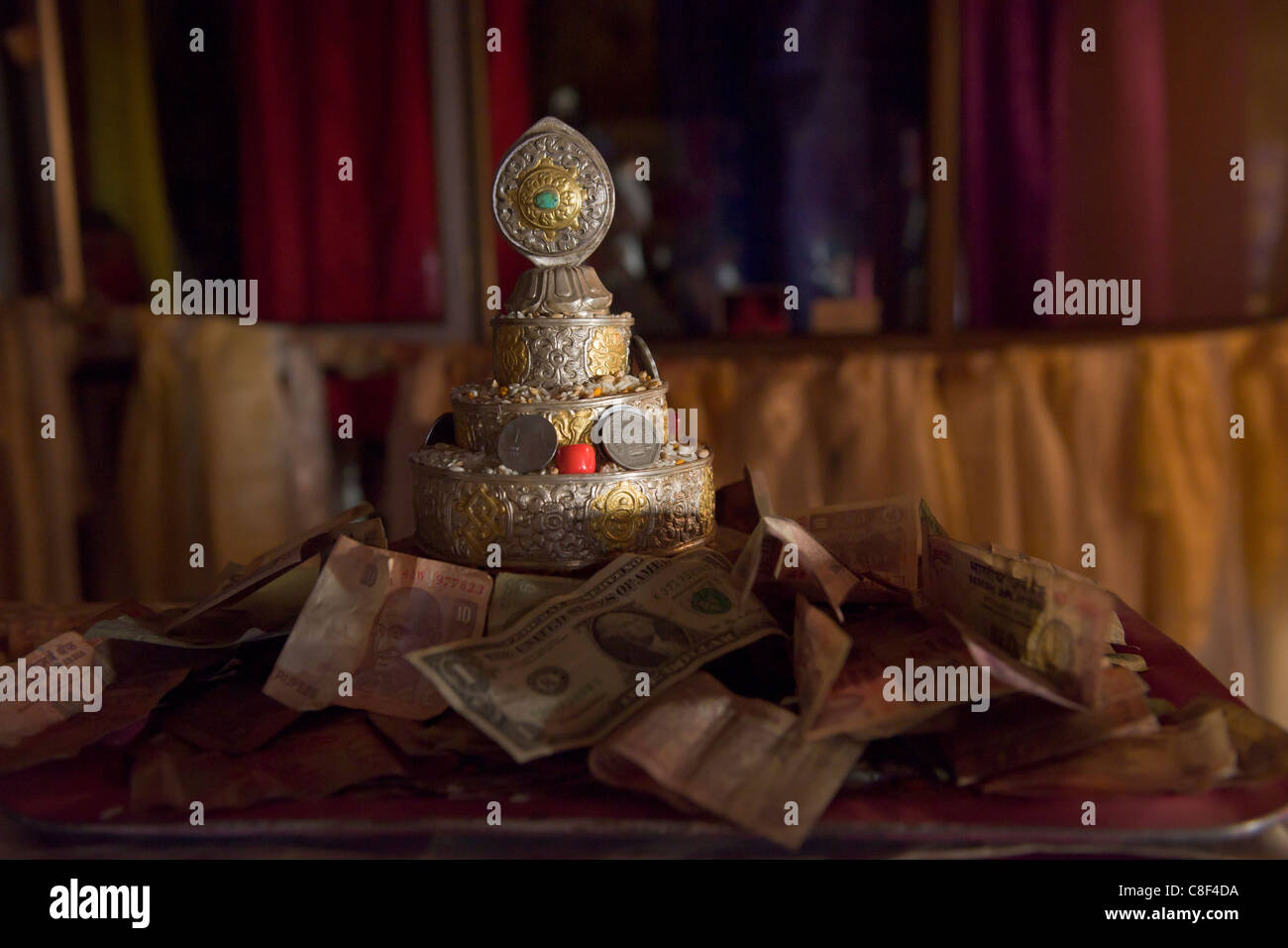Buddhist offerings of rice, coins and notes, Likir Gompa, (Ladakh ...