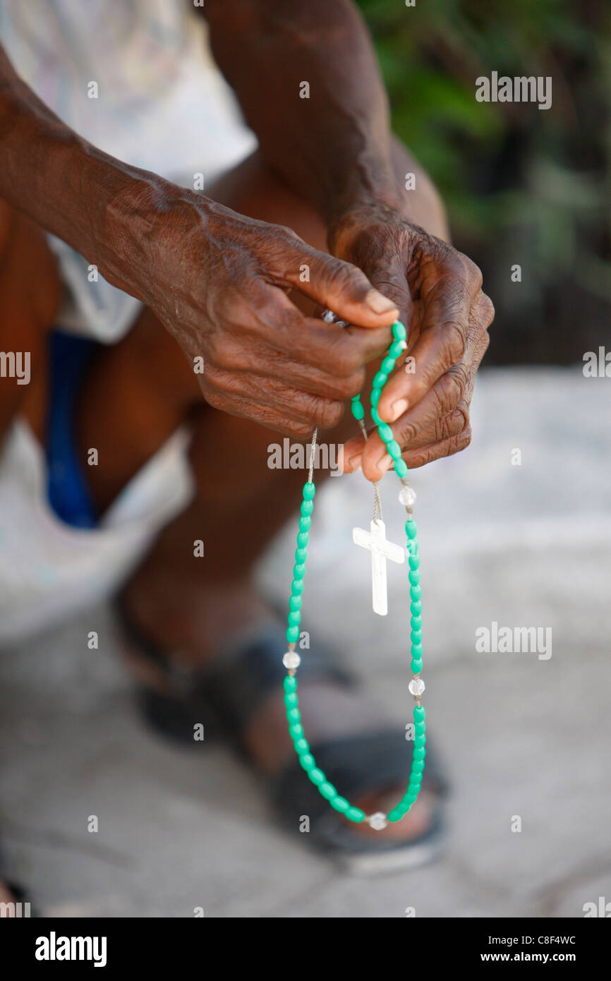Haitian woman praying with prayer beads, Port au Prince, Haiti, West Indies, Central America ...
