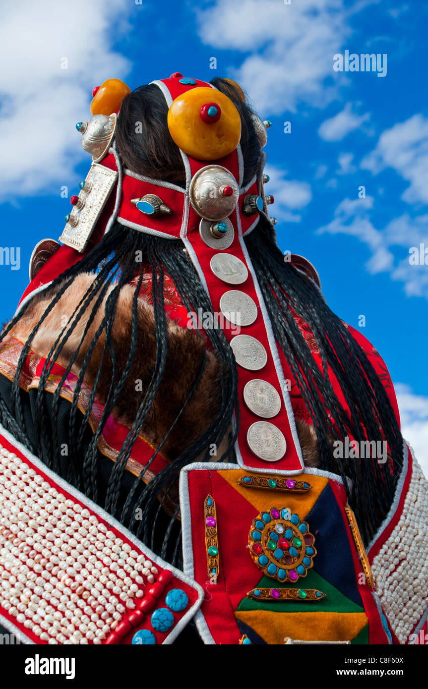 Back view of Tibetan woman's traditional headdress at festival, Gerze ...
