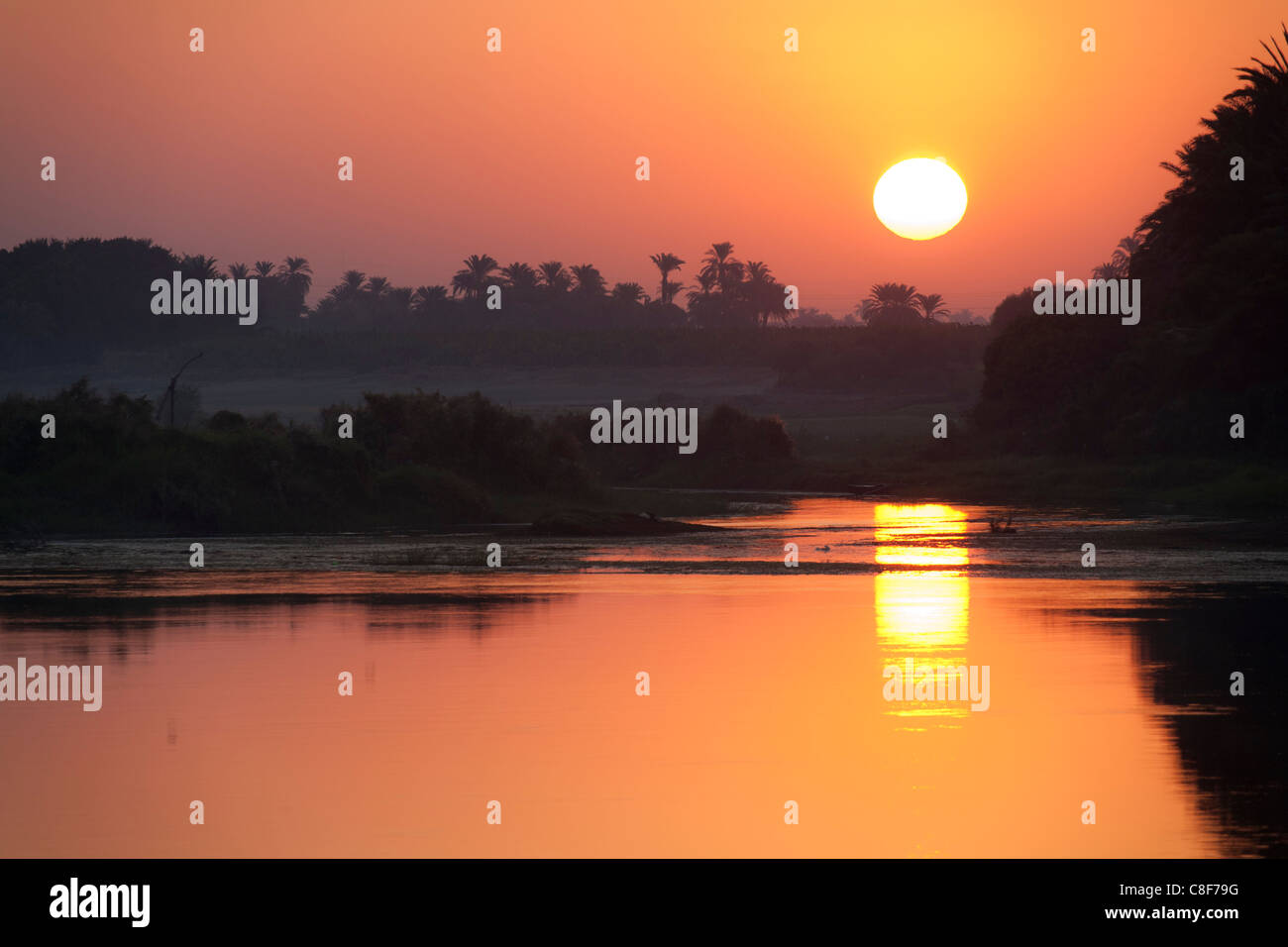 Golden sun disc reflected in the river Nile at sunrise, Egypt, Africa ...