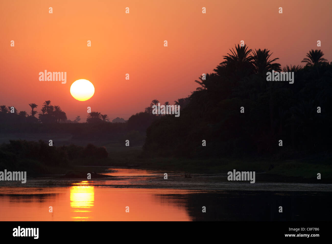 Golden sun disc reflected in the river nile at sunrise hi-res stock ...