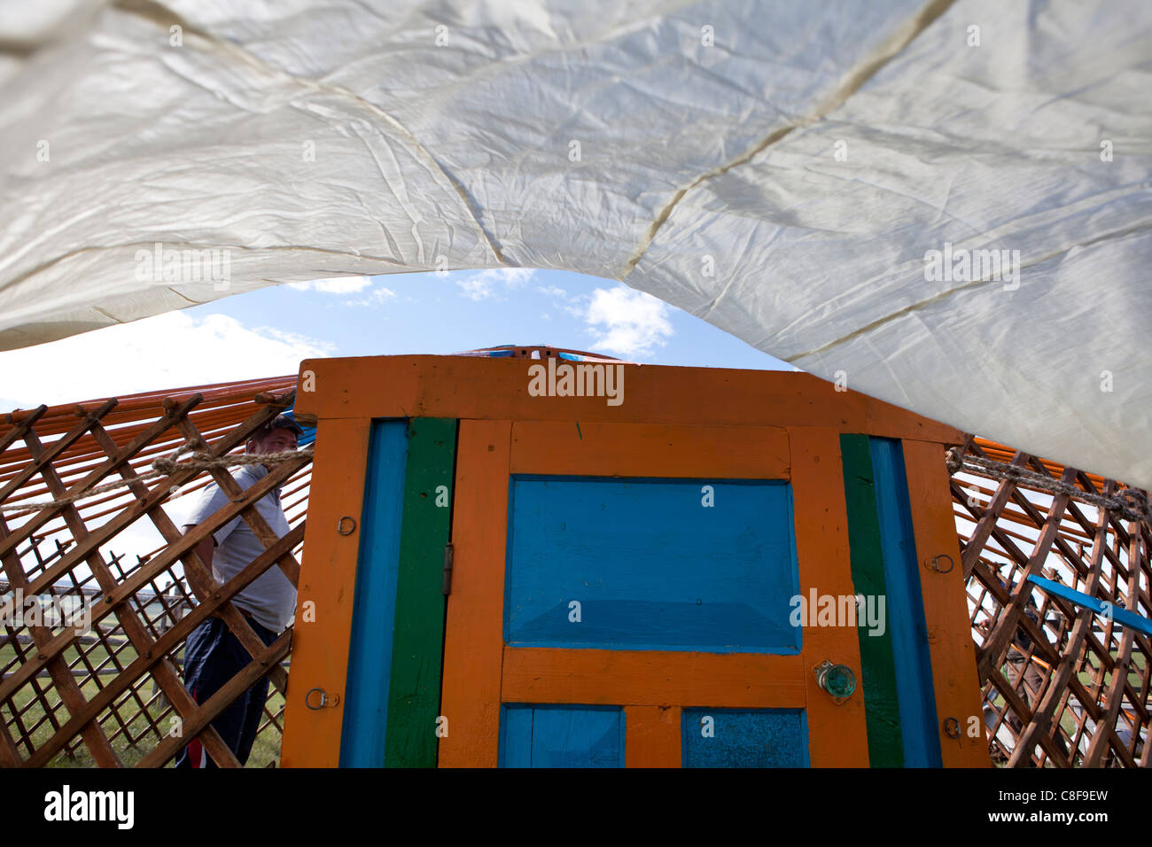 Mongolian man build ger, covering roof by fabric and door, Tsagaan Nuur ...