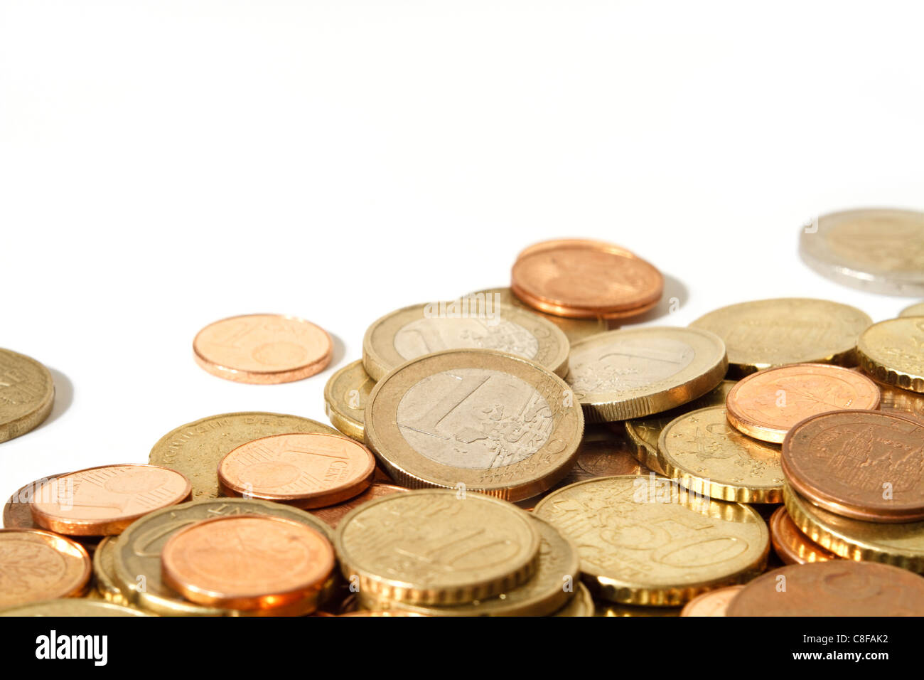 The edge of a pile of modern Euro coins with white copy space at the ...