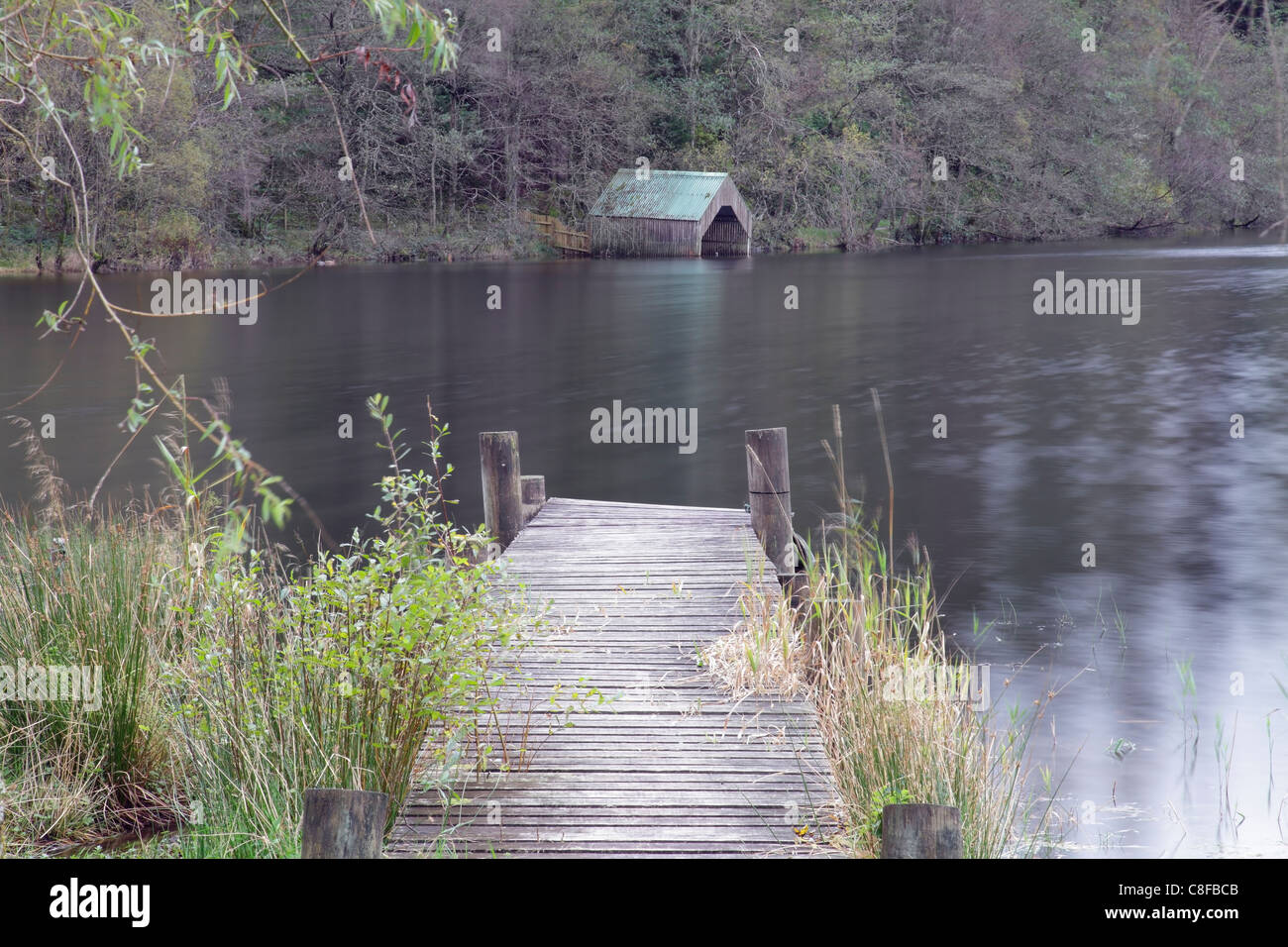 A boathouse and jetty in Loch Ard in autumn in the Trossachs Scotland ...