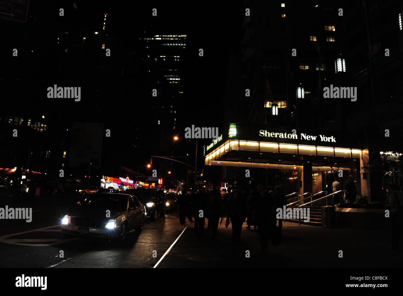 Black sky night-time view cars parked people walking front Hotel ...