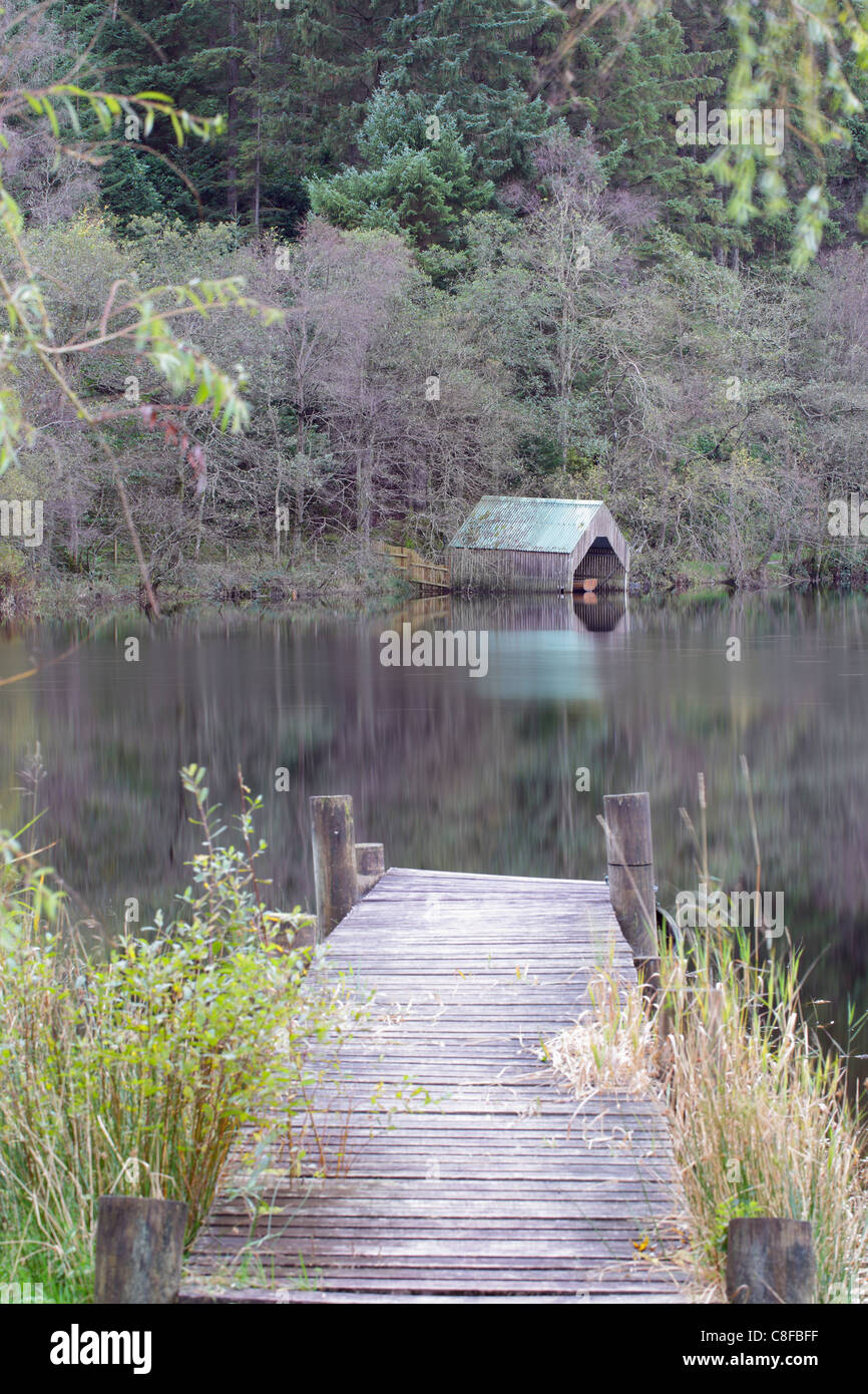 A boathouse and jetty in Loch Ard in autumn in the Trossachs Scotland ...