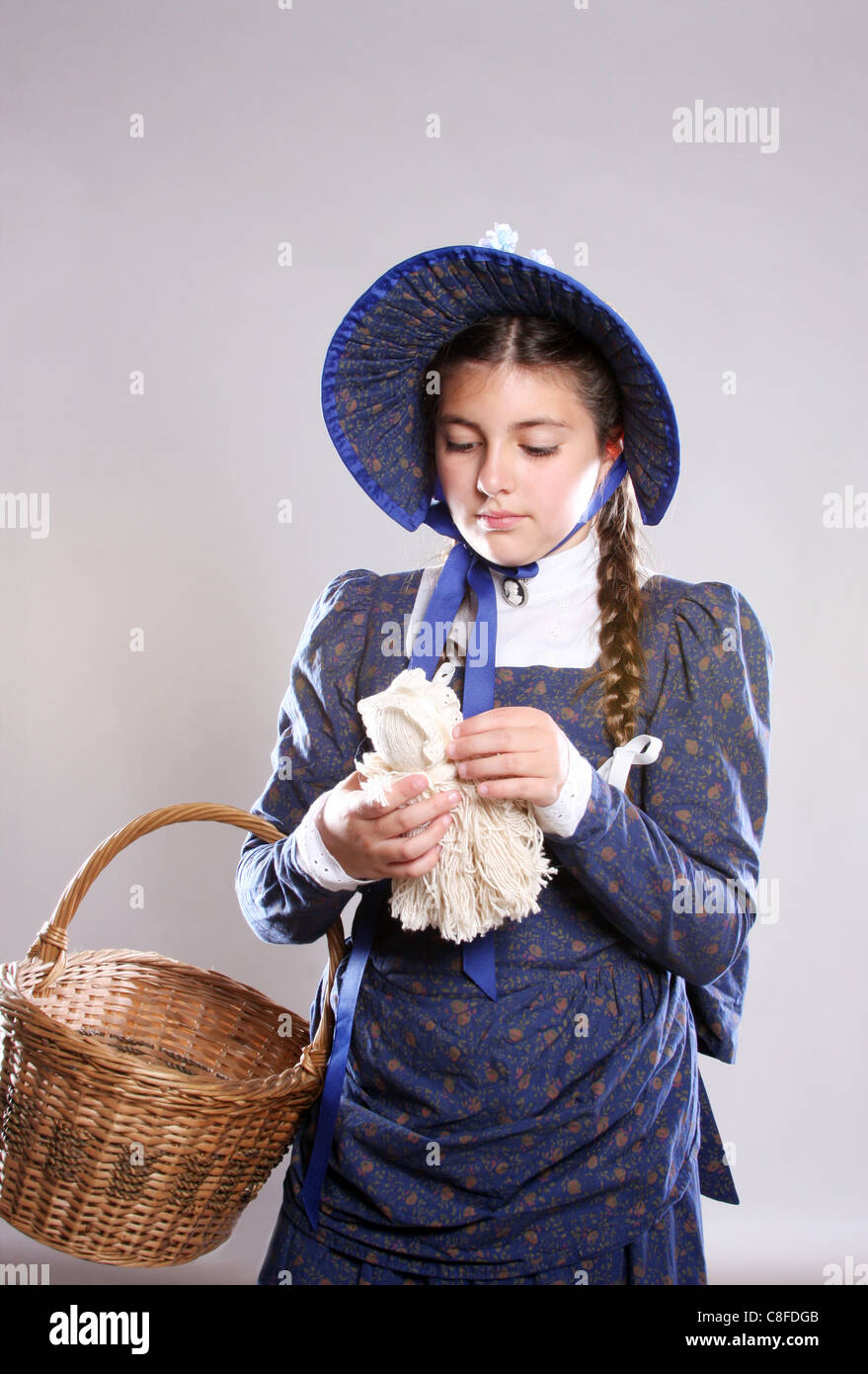 A victorian dressed girl holding a string doll Stock Photo - Alamy