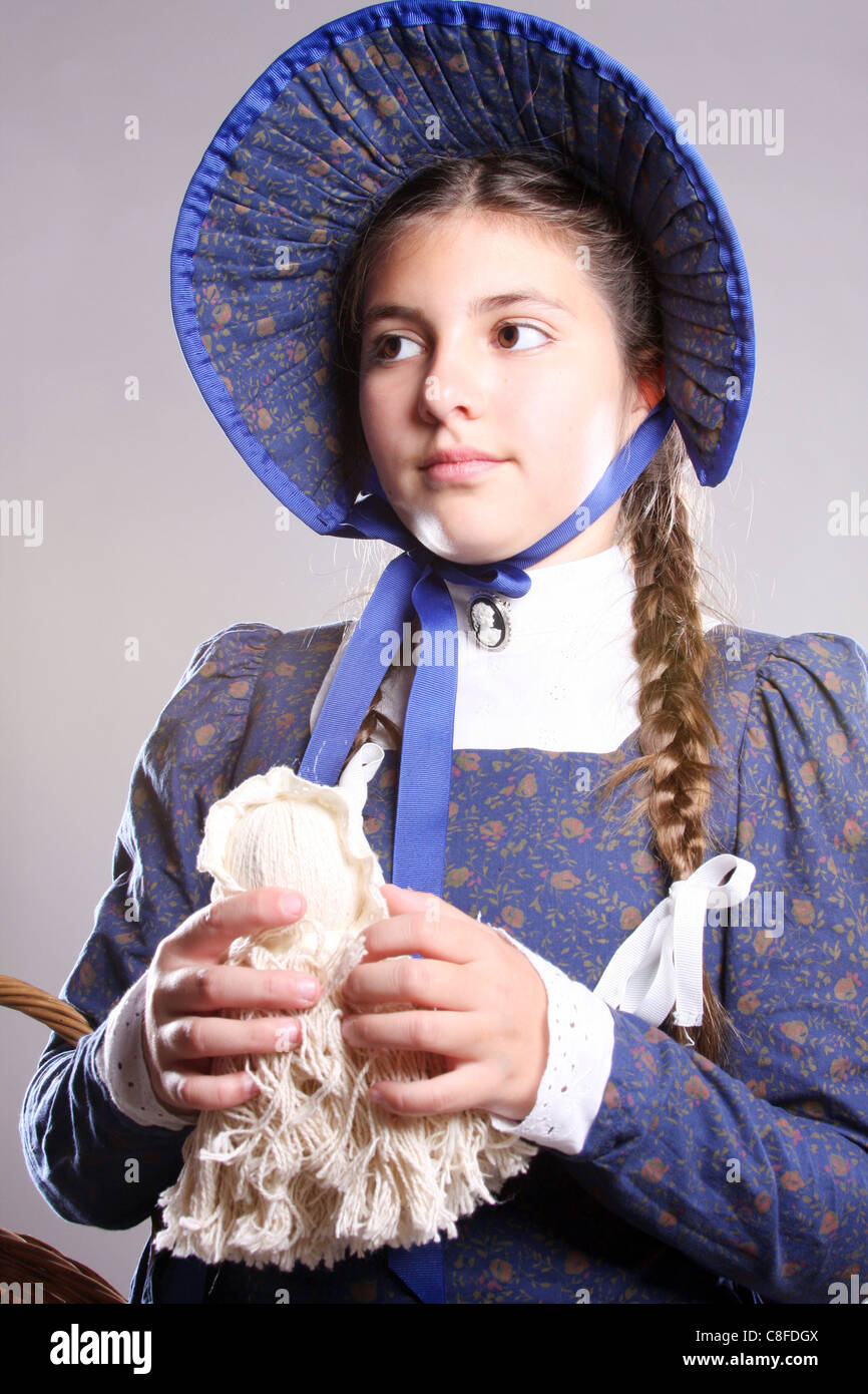A victorian dressed preteen girl holding a toy string doll Stock Photo ...