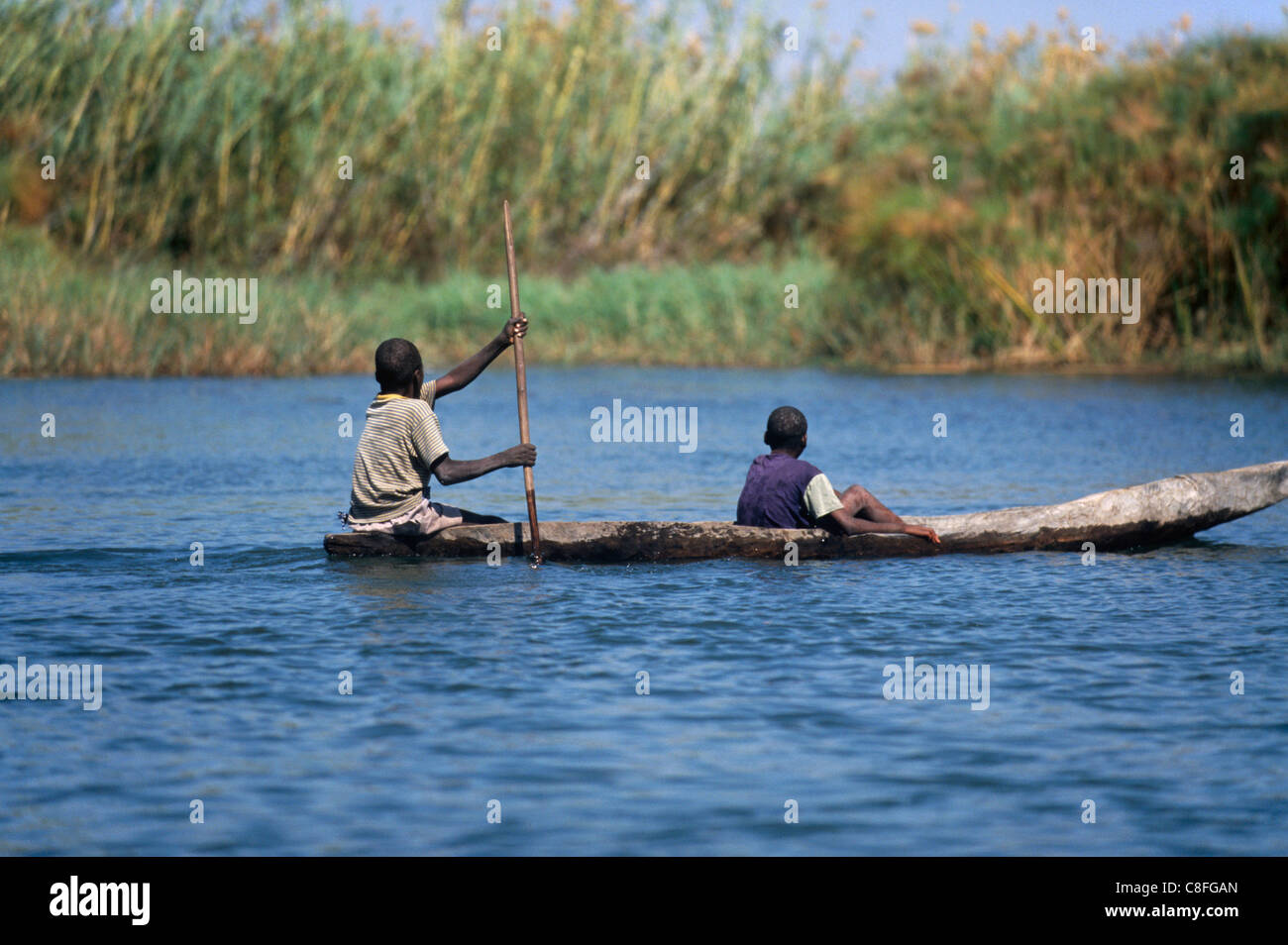 Two children in a mokoro (makoro) (mekoro, Okavango River, Botswana ...