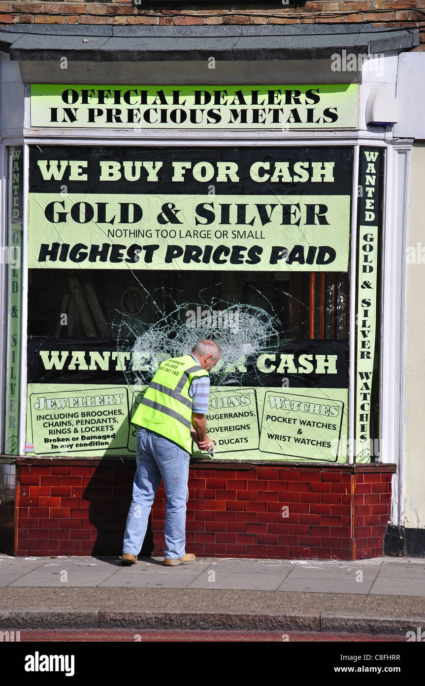 Man fixing smashed shop window, Camberwell New Road, Camberwell, London ...