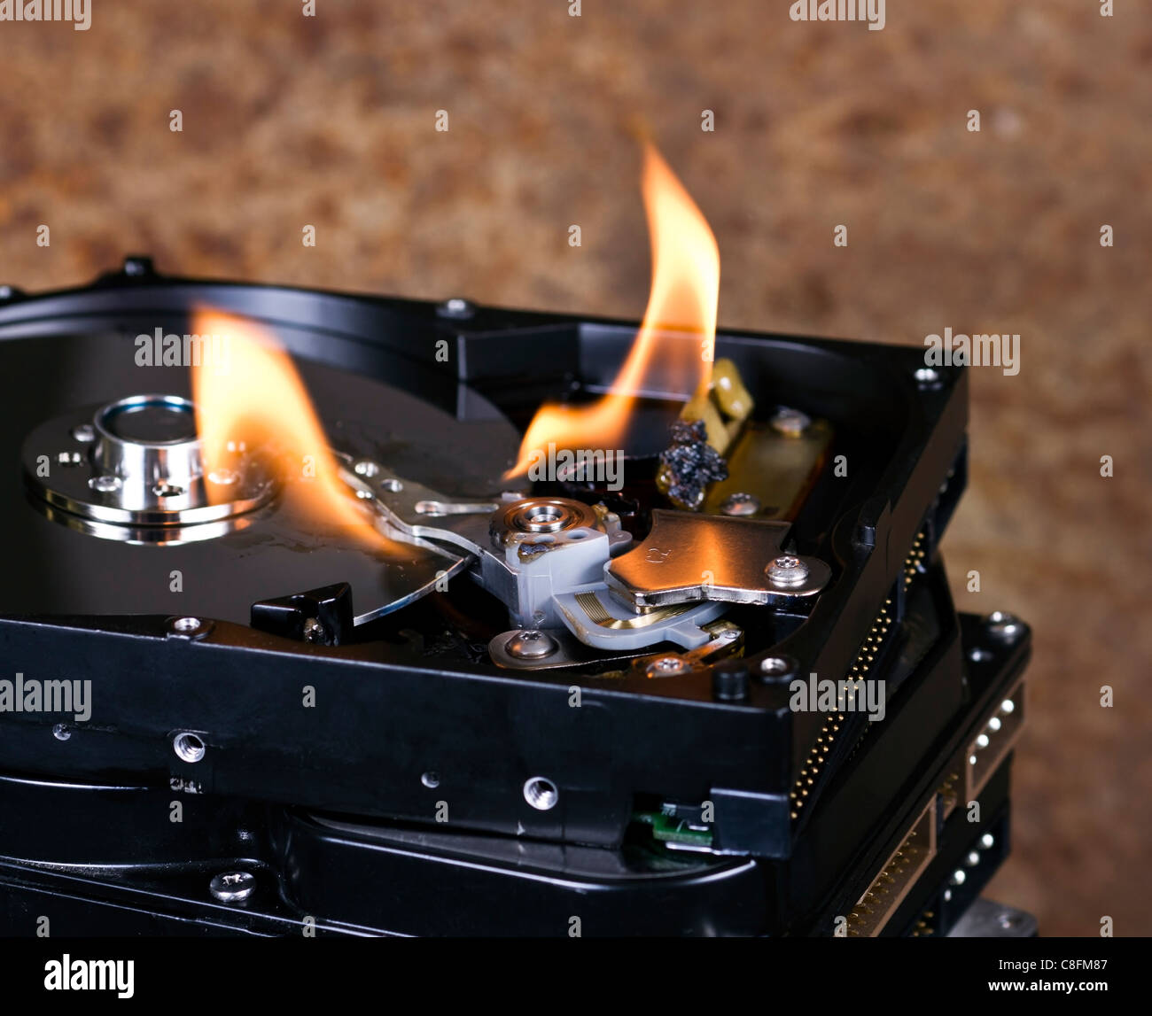 burning stack of hard disks in front of rusty back Stock Photo - Alamy
