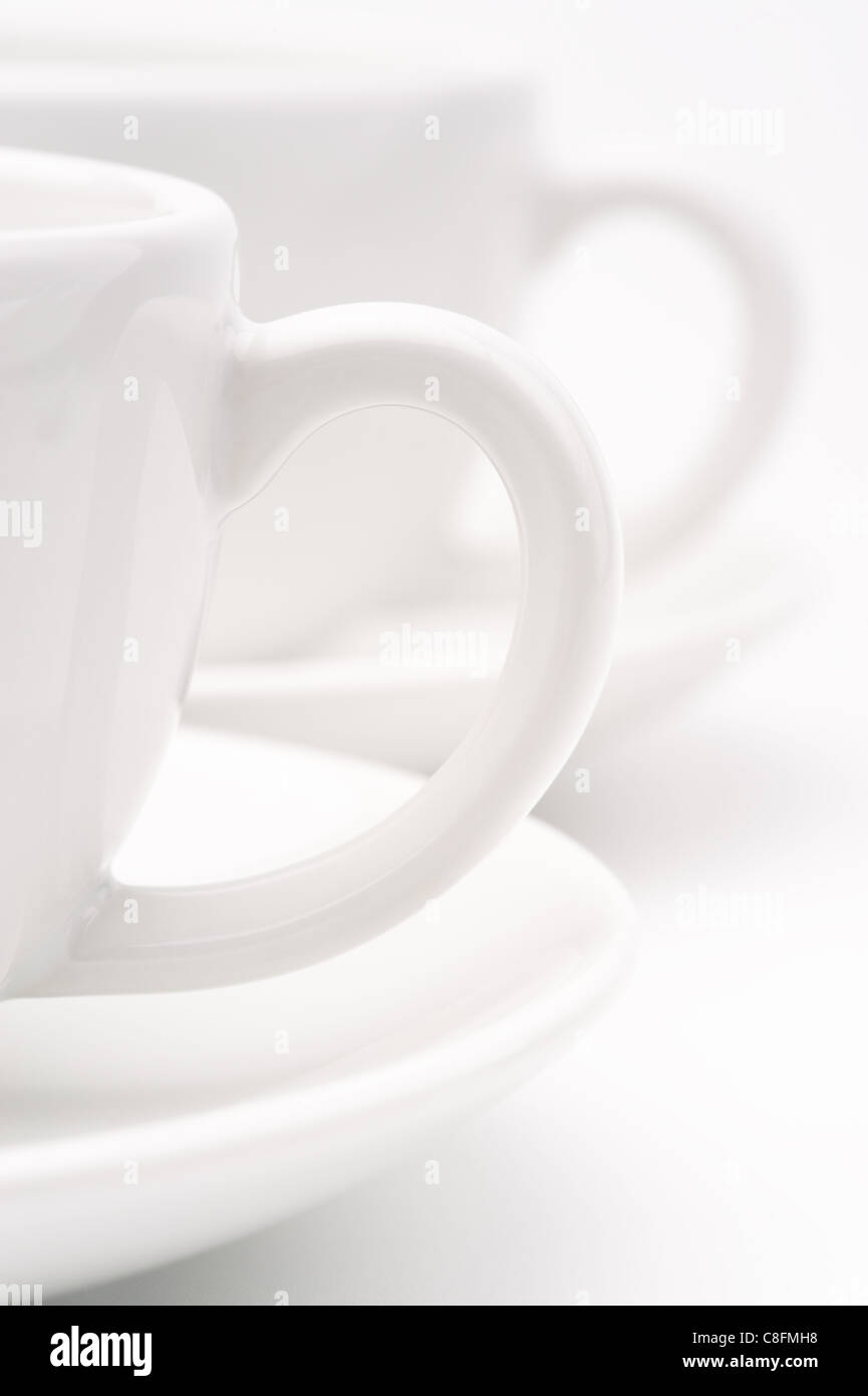 A pair of white tea cups on a white background, selective focus, simple ...