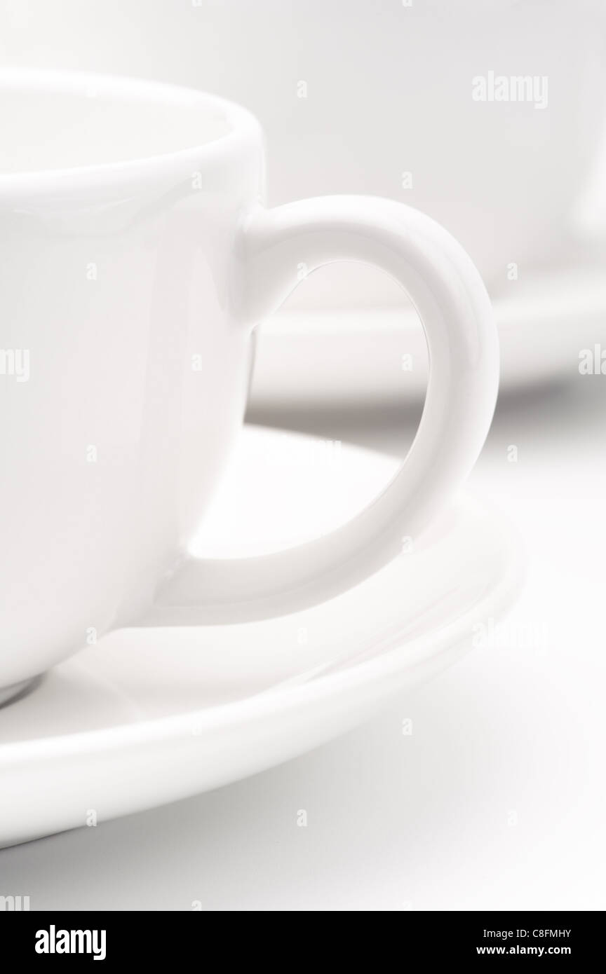 A pair of white tea cups on a white background, selective focus, simple ...